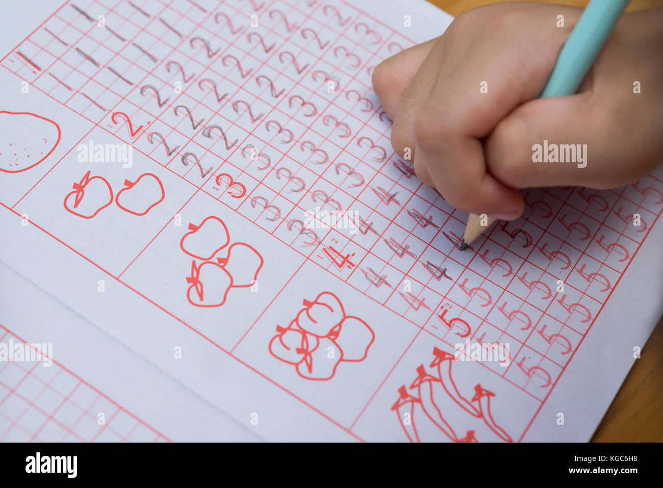 kid learns to write Arabic numerals by following guides Stock Photo - Alamy