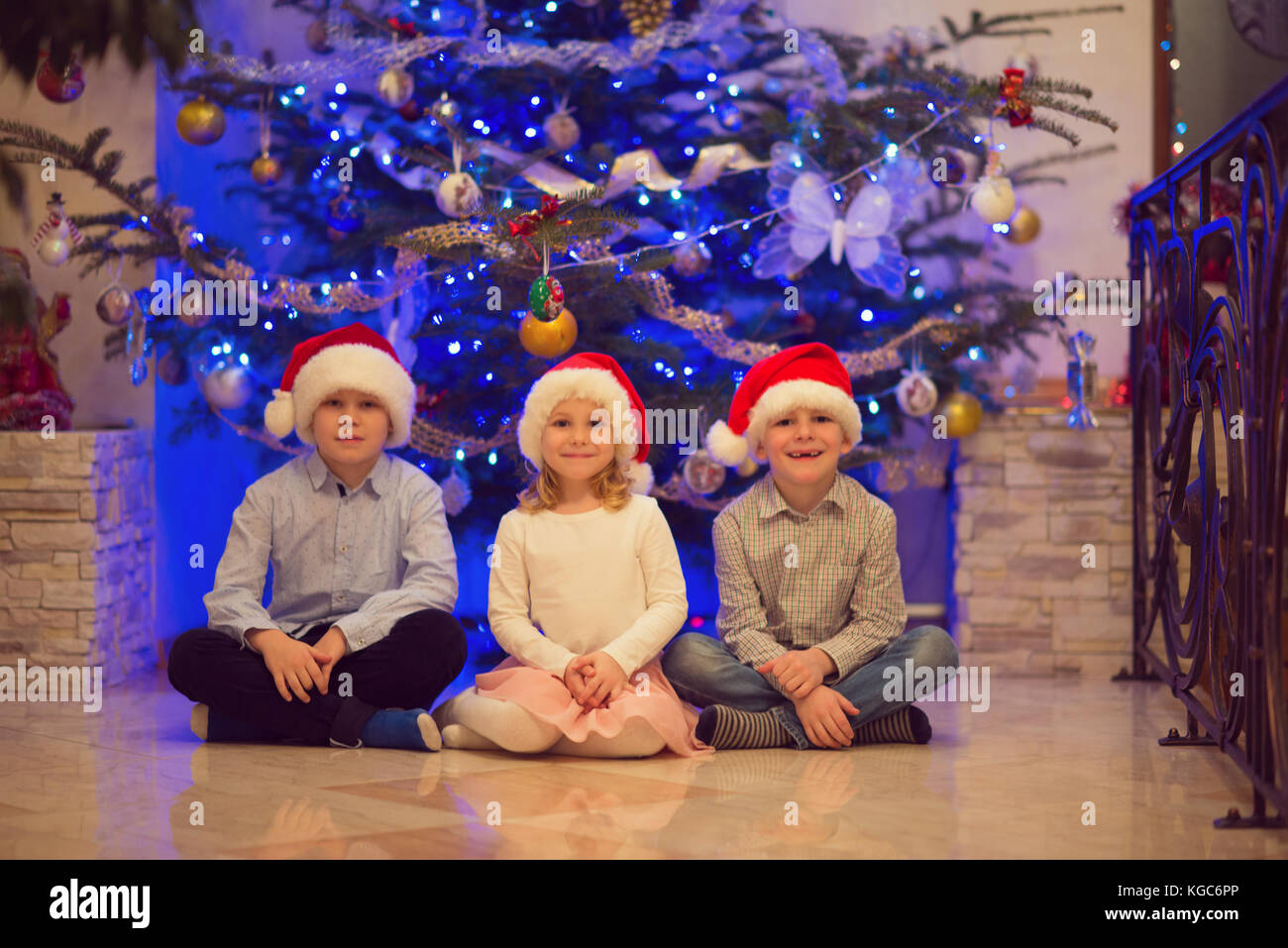 Portrait of three happy children having fun at Christmas eve at home ...