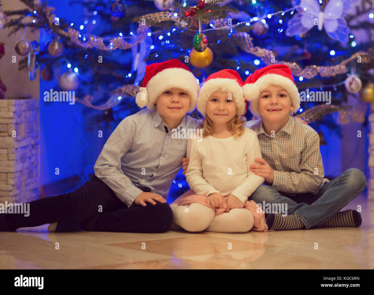 Portrait of three happy children having fun at Christmas eve at home ...