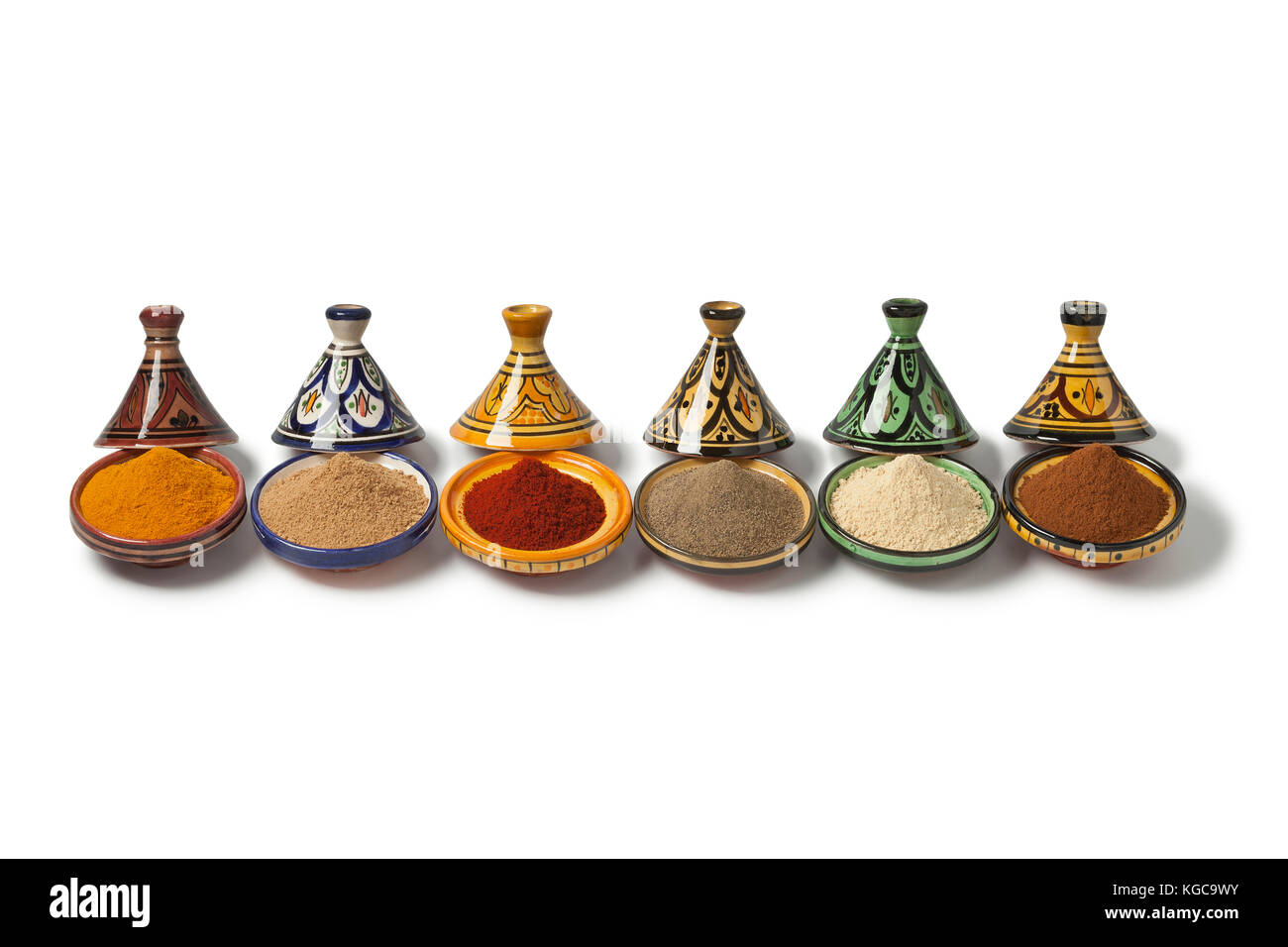 Diversity of Moroccan powder herbs in colorful ceramic tagines on white ...
