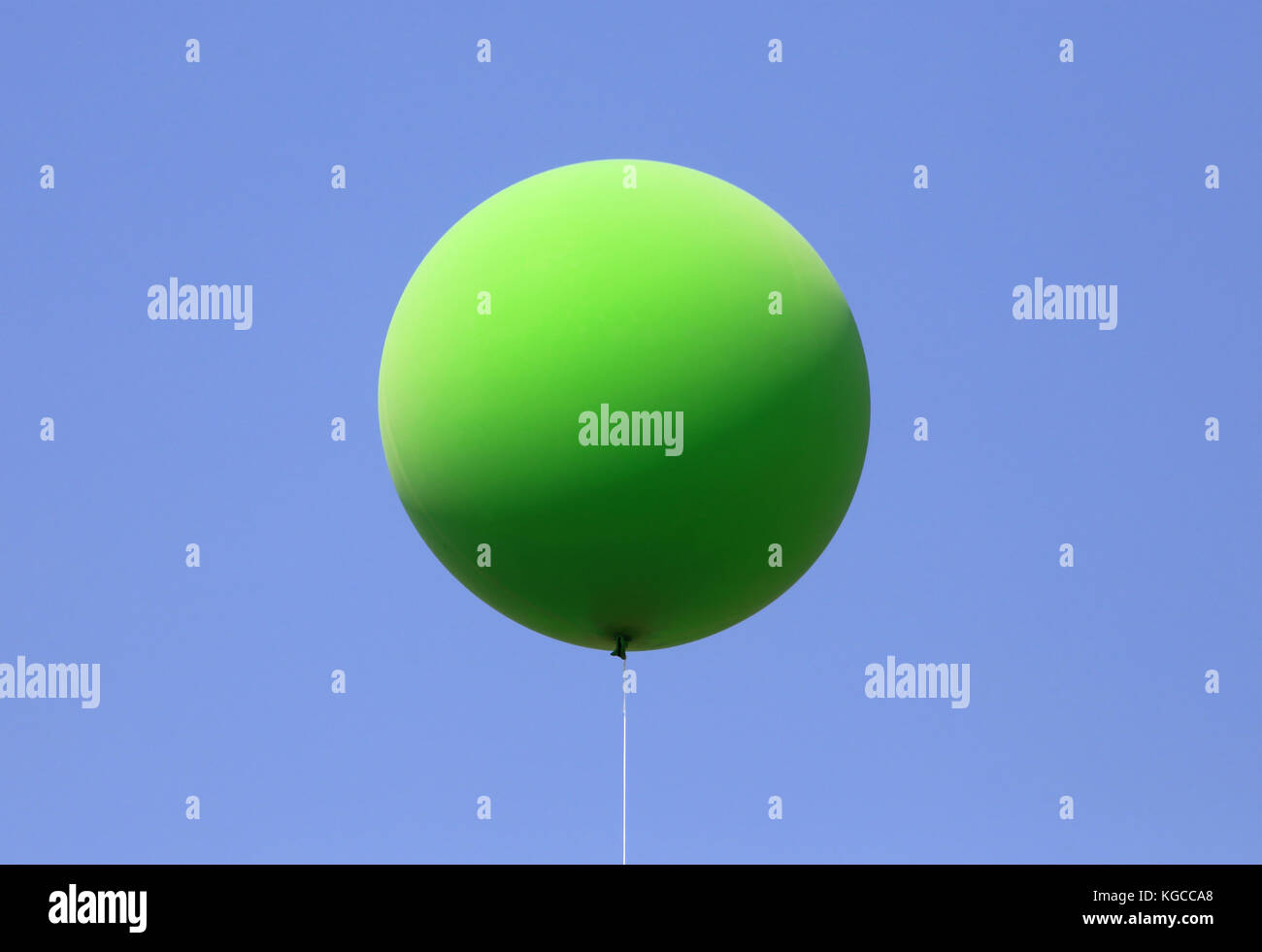 Green balloon on blue sky background Stock Photo - Alamy