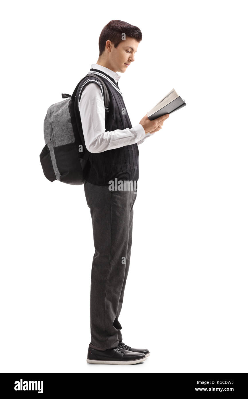 Full length profile shot of a teenage student reading a book and ...