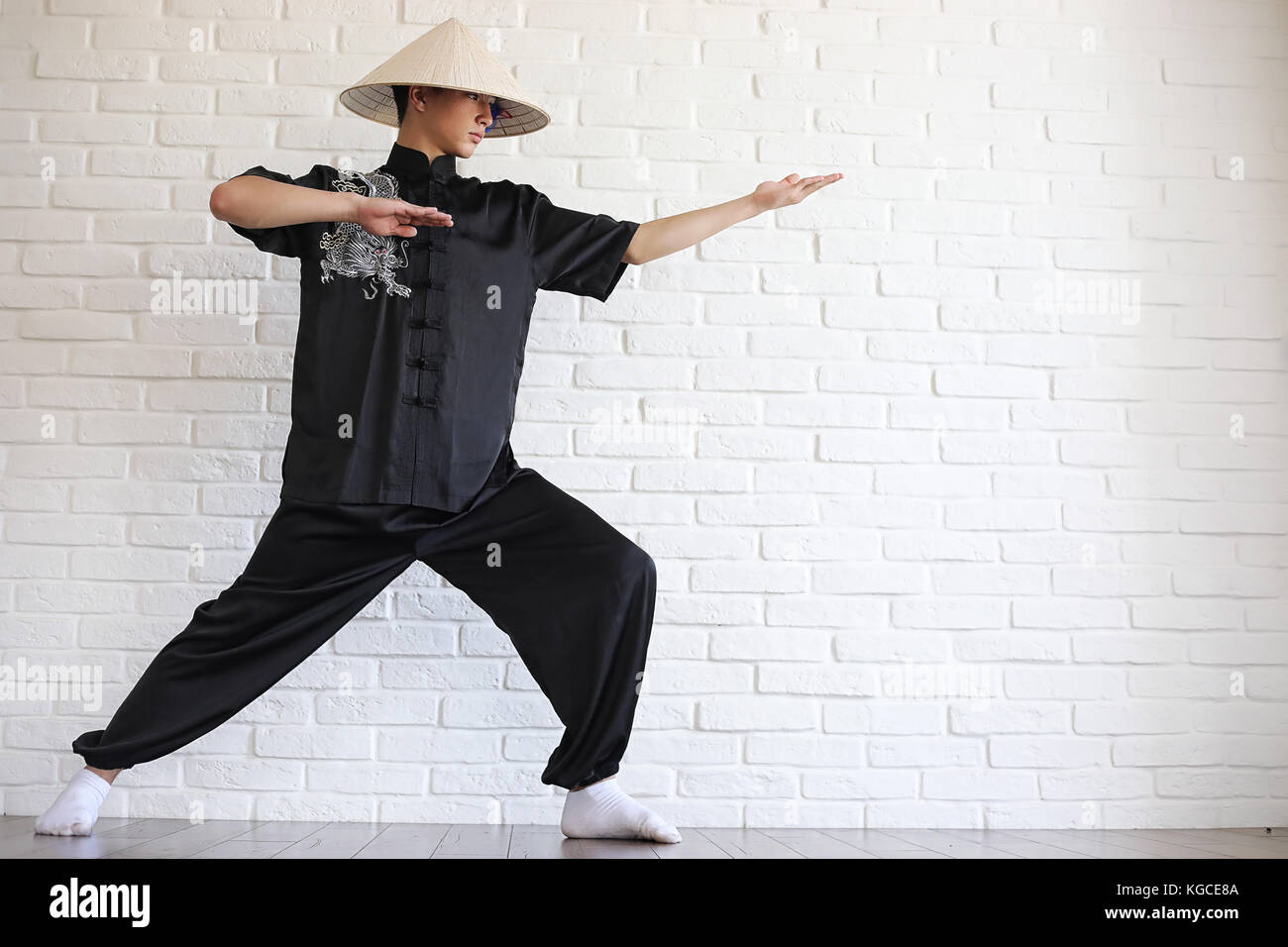 Asian young novice on a white brick wall Stock Photo - Alamy