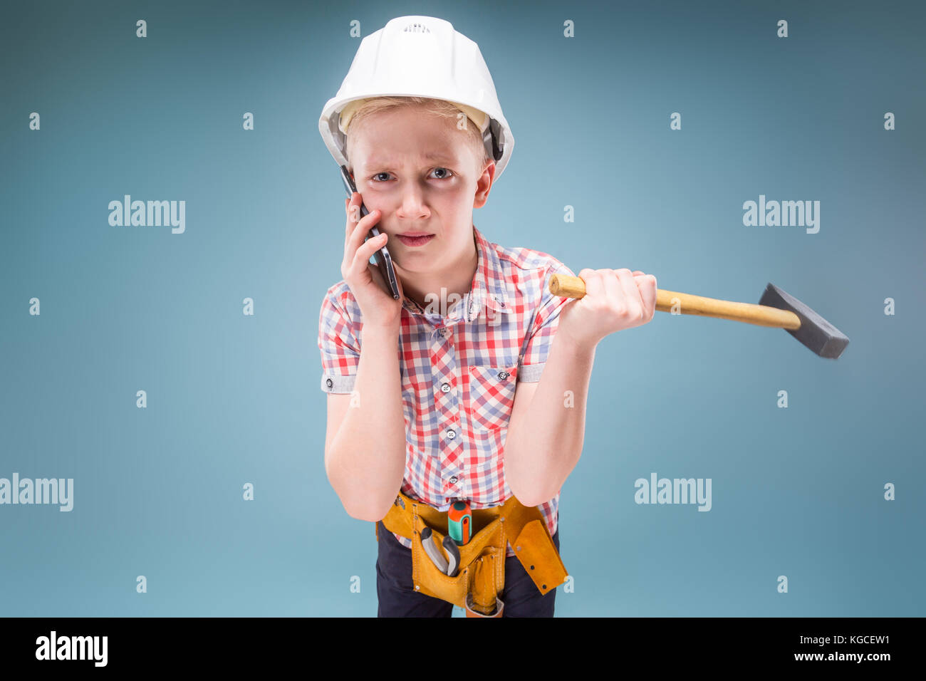confused construction worker talking on the phone with a hammer in his ...
