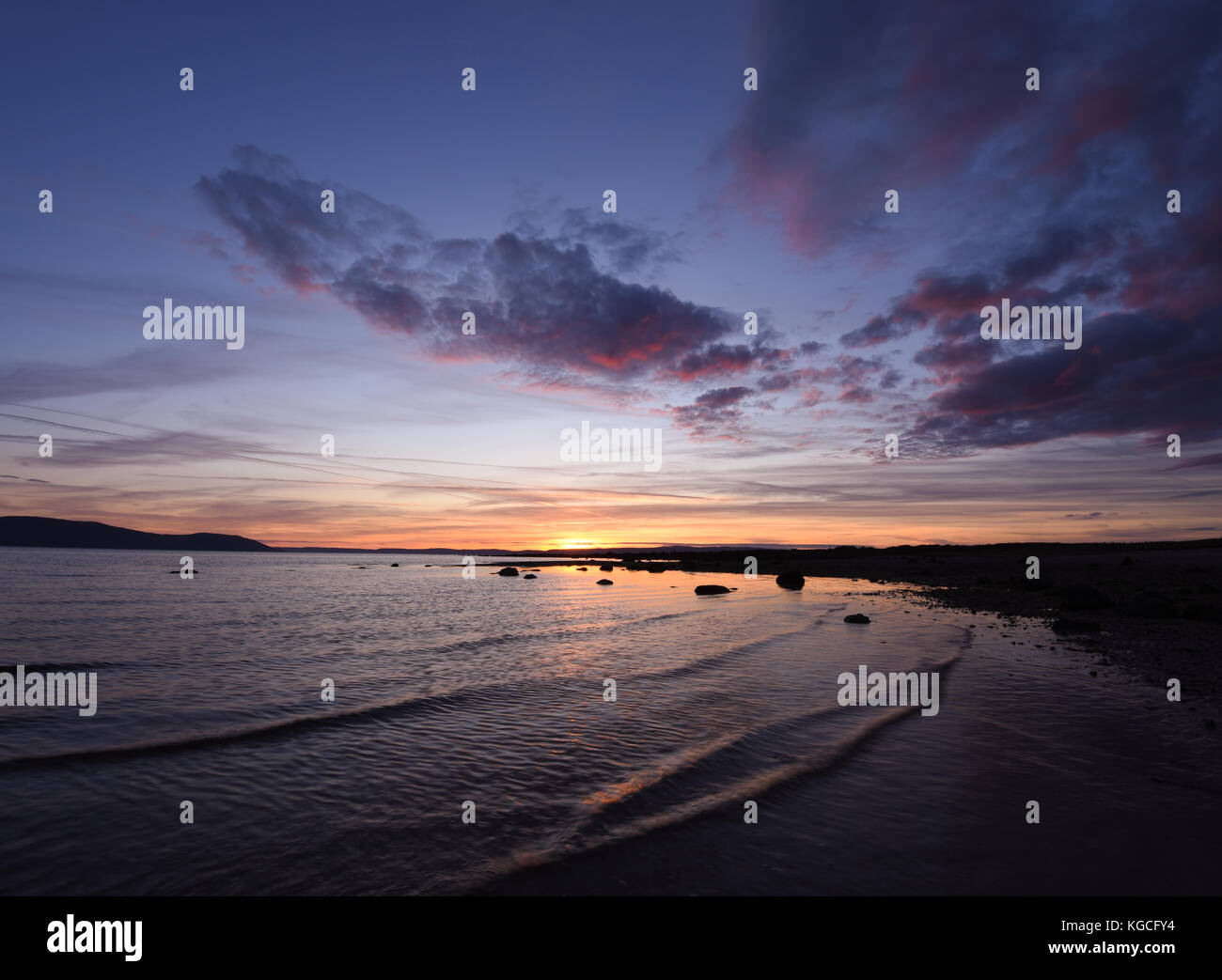 View of Arran at sunset from the soft sands of the Isle of Bute Stock ...