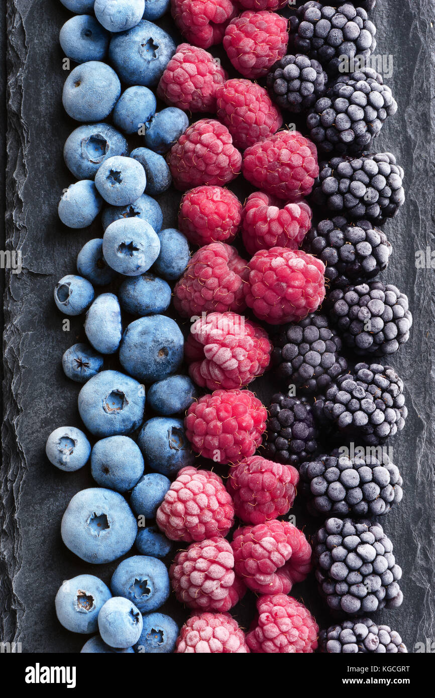 Frozen berries on black slate. Blueberry, raspberry, blackberry. Top ...