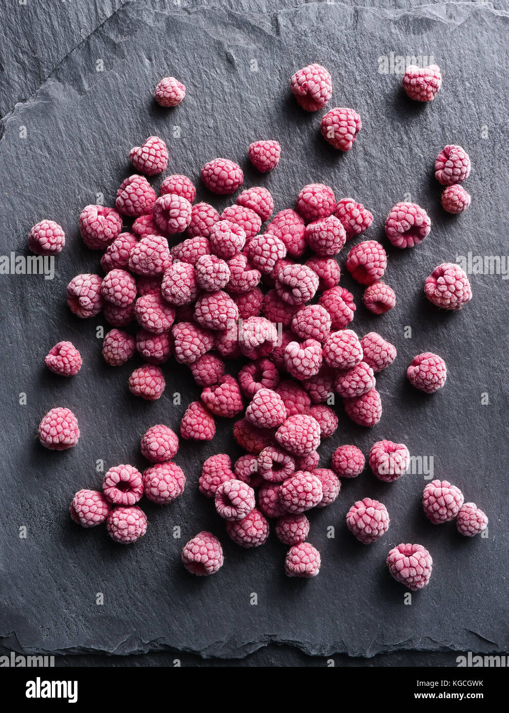 Frozen raspberry on black slate. Top view. High resolution product ...