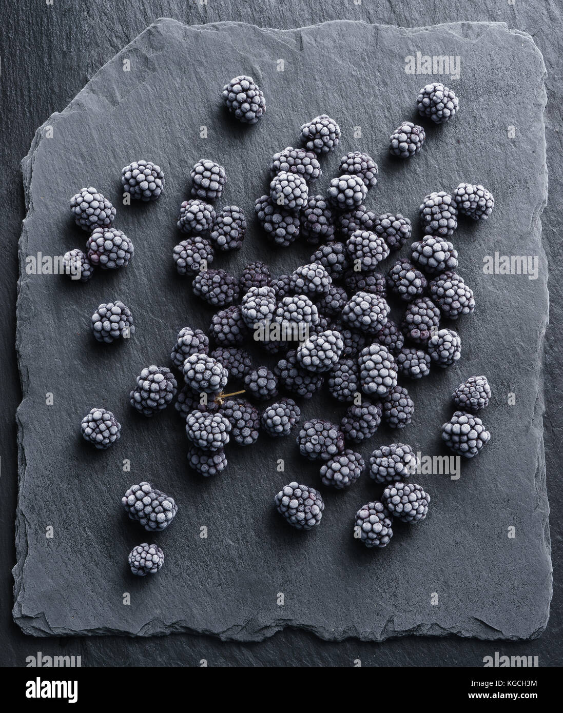 Frozen blackberry on black slate. Top view. High resolution product ...