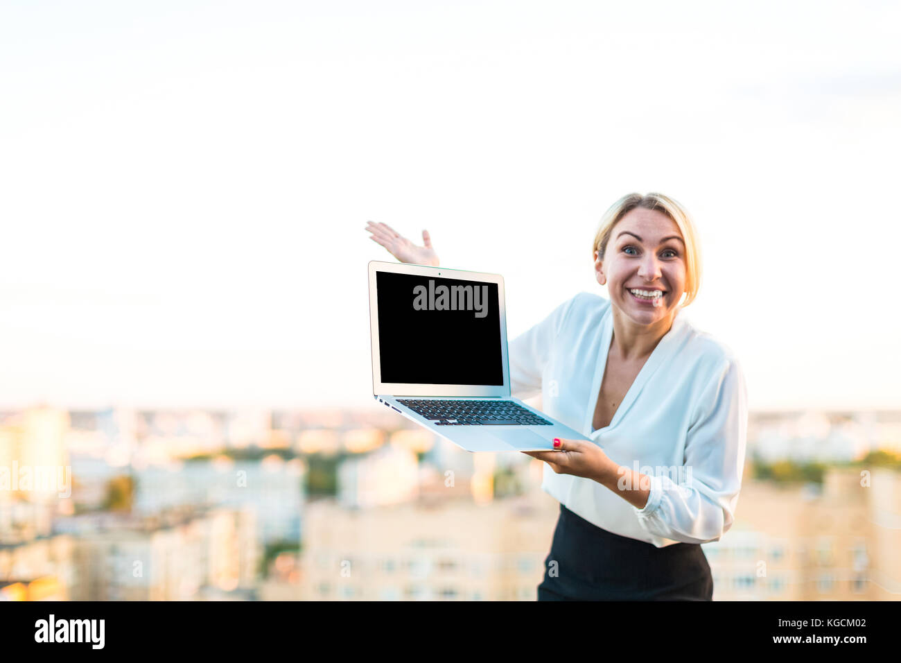 Beautiful smart business lady stand on the roof with laptop in h Stock ...