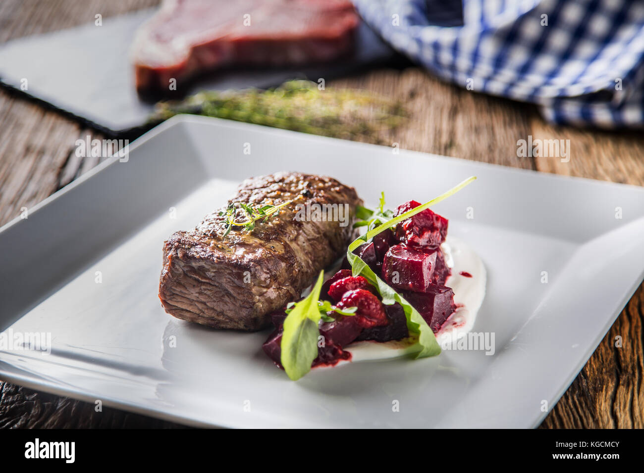 Beef steak with beetroot and herb decoration. Beef steak on plate in ...