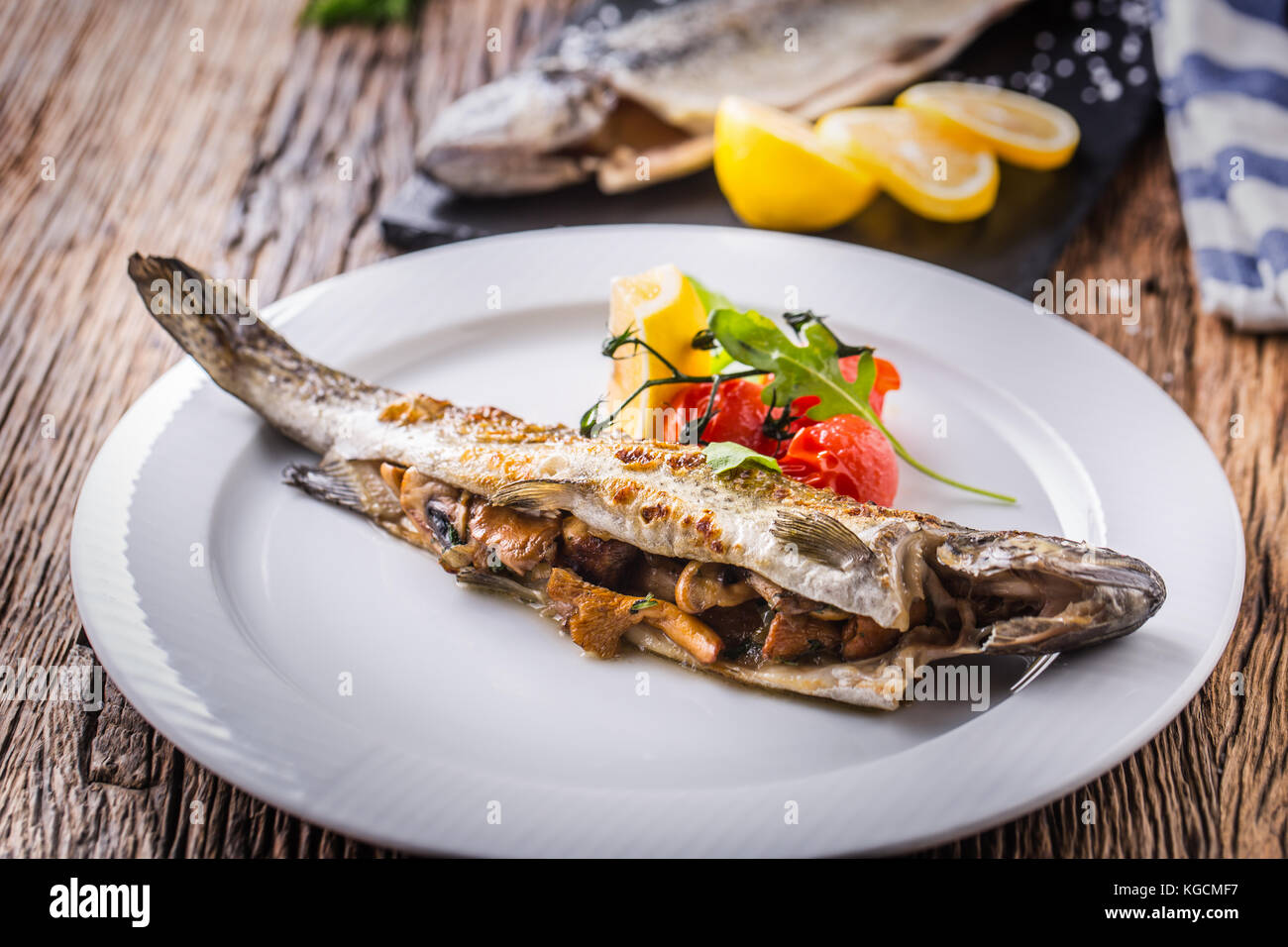 Fish trout with mushrooms and vegetable on plate in hotel or restaurant ...