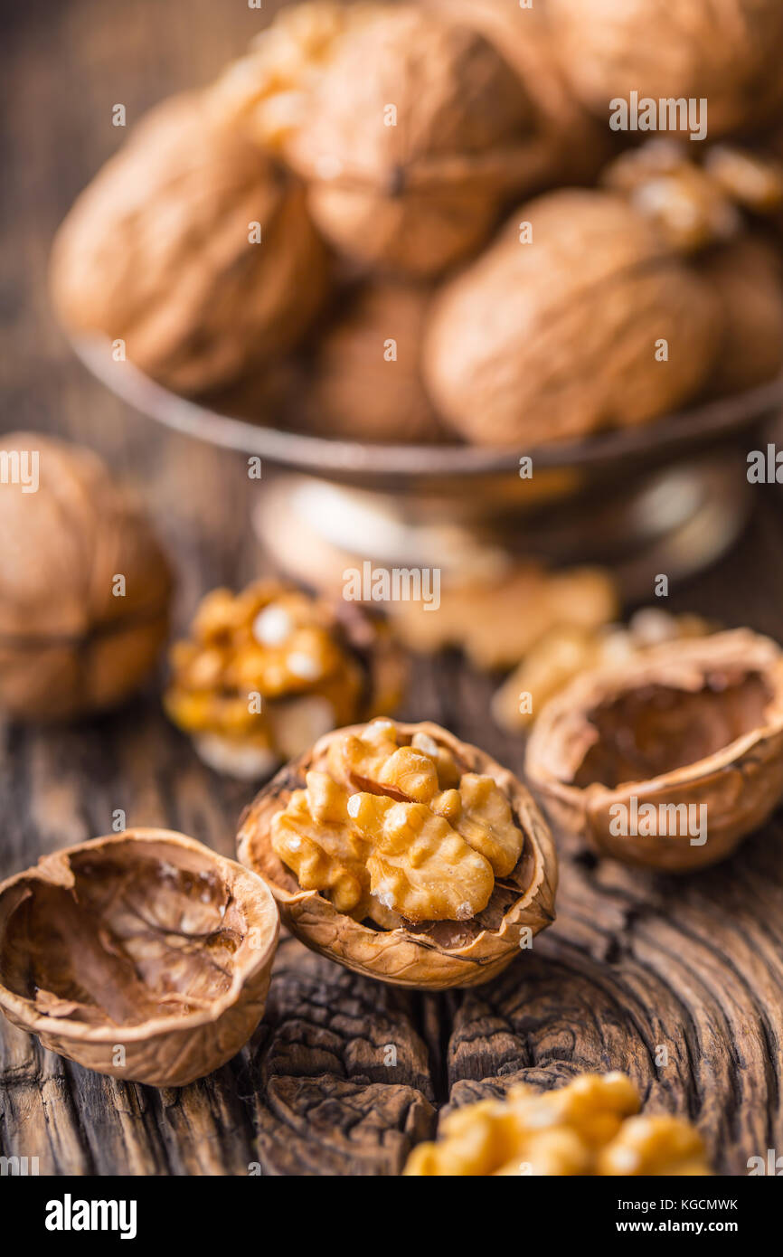 Walnut. Walnut kernels and whole walnuts on rustic old oak table Stock ...