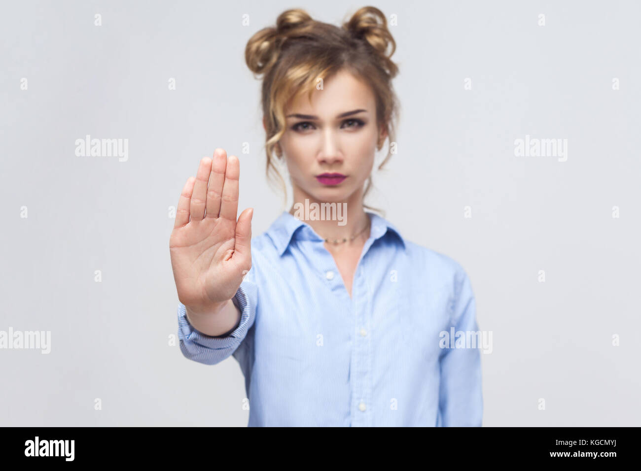 Blonde woman with bad attitude making stop gesture with her palm ...