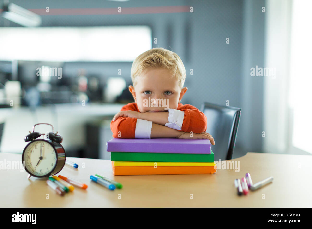 Young boy sit at the desk in the office Stock Photo - Alamy