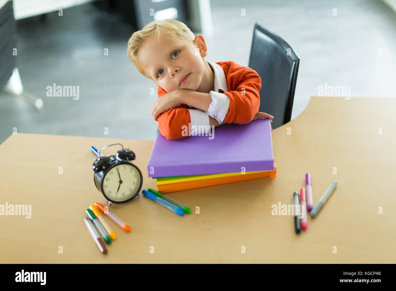 Young boy sit at the desk in the office Stock Photo - Alamy