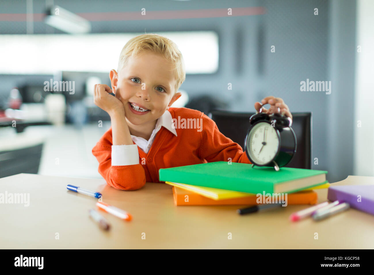 Young boy sit at the desk in the office Stock Photo - Alamy