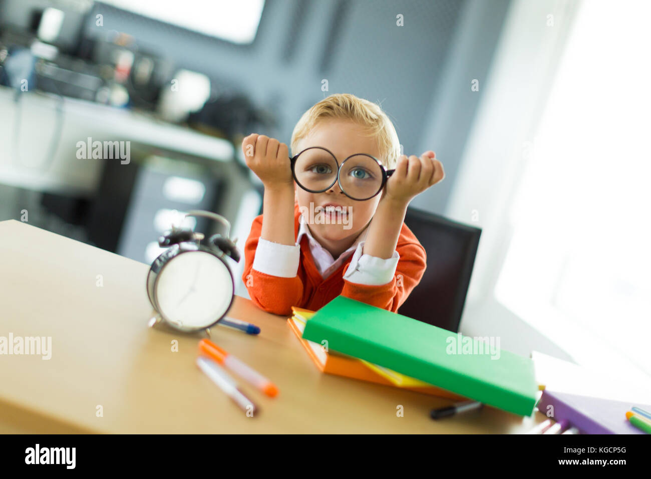 Young boy sit at the desk in the office Stock Photo - Alamy