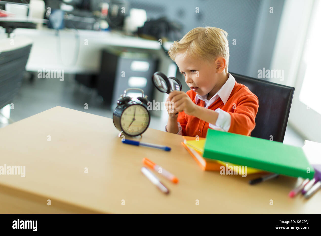 Young boy sit at the desk in the office Stock Photo - Alamy