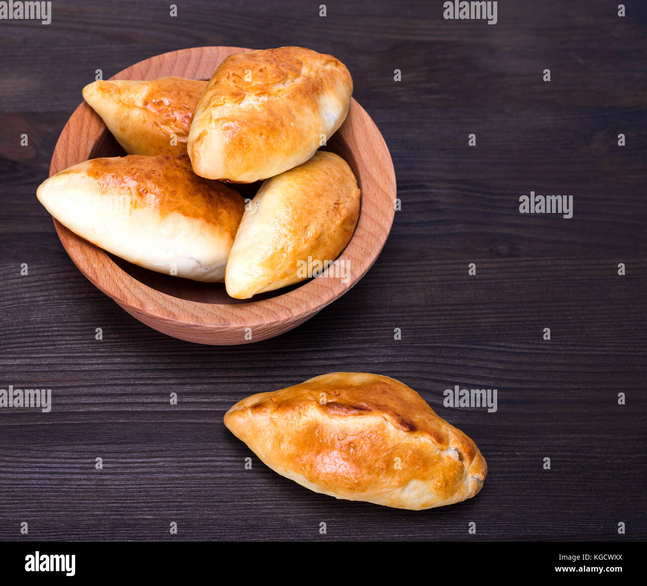 baked patties in a wooden bowl on a brown wooden background, top view ...