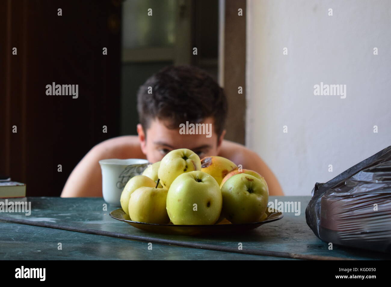 Man behind plate of apples Stock Photo - Alamy