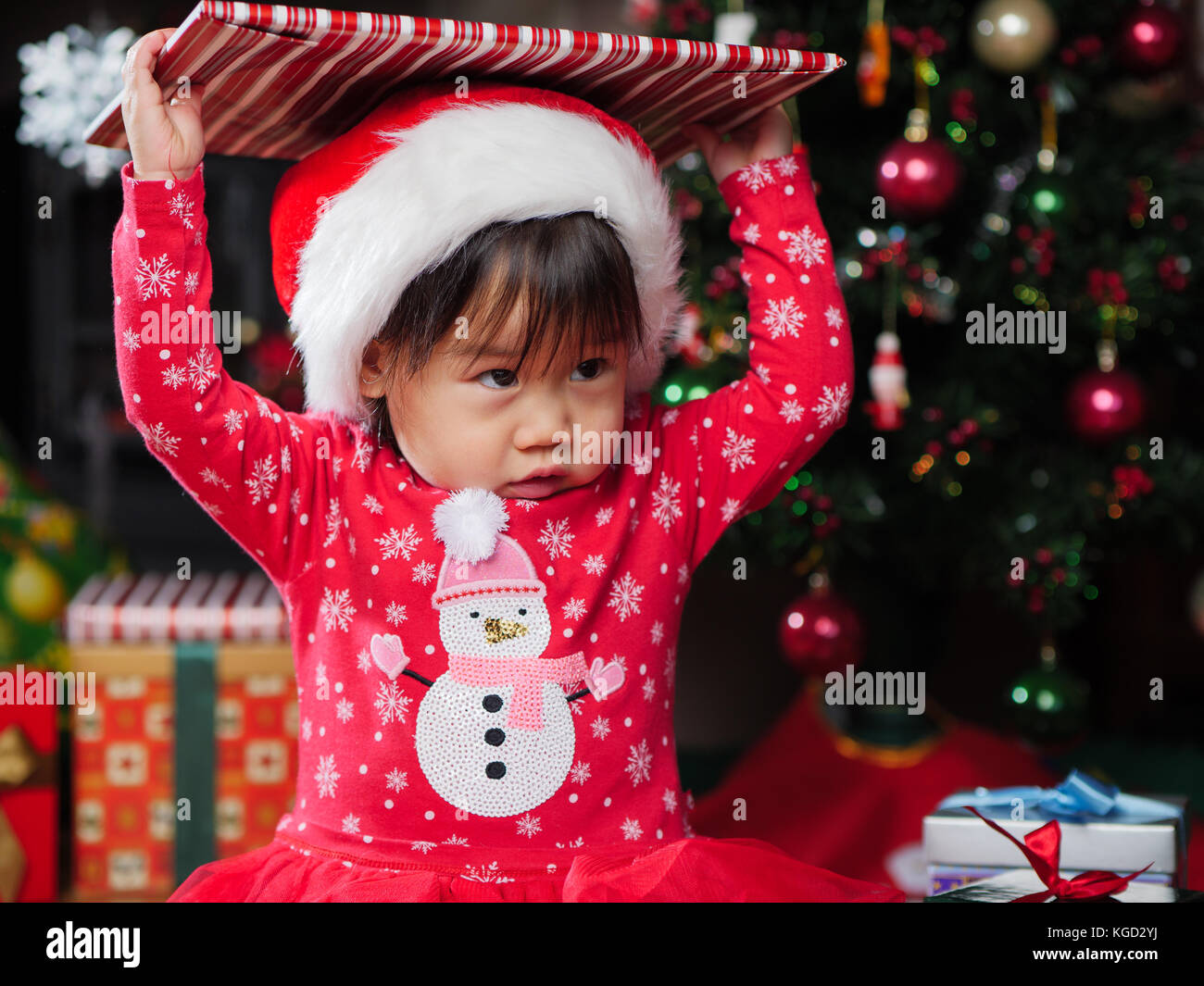 Santa baby girl opening her Christmas gift Stock Photo - Alamy