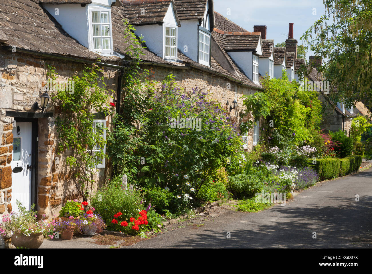 A row of stone cottages and colourful summer gardens in Blacksmiths ...