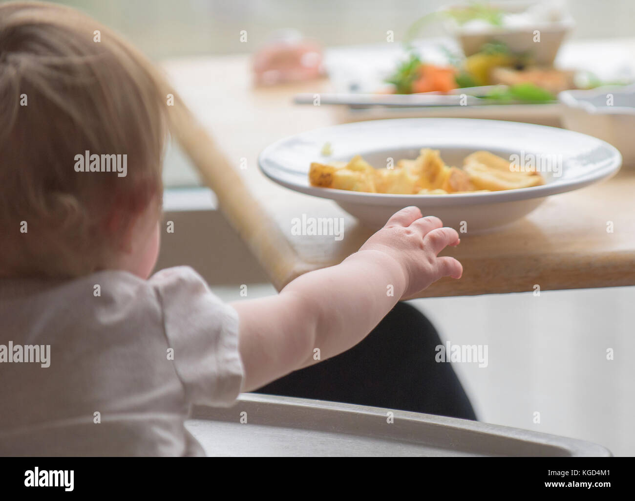 A hungry toddler reaching for food Stock Photo - Alamy