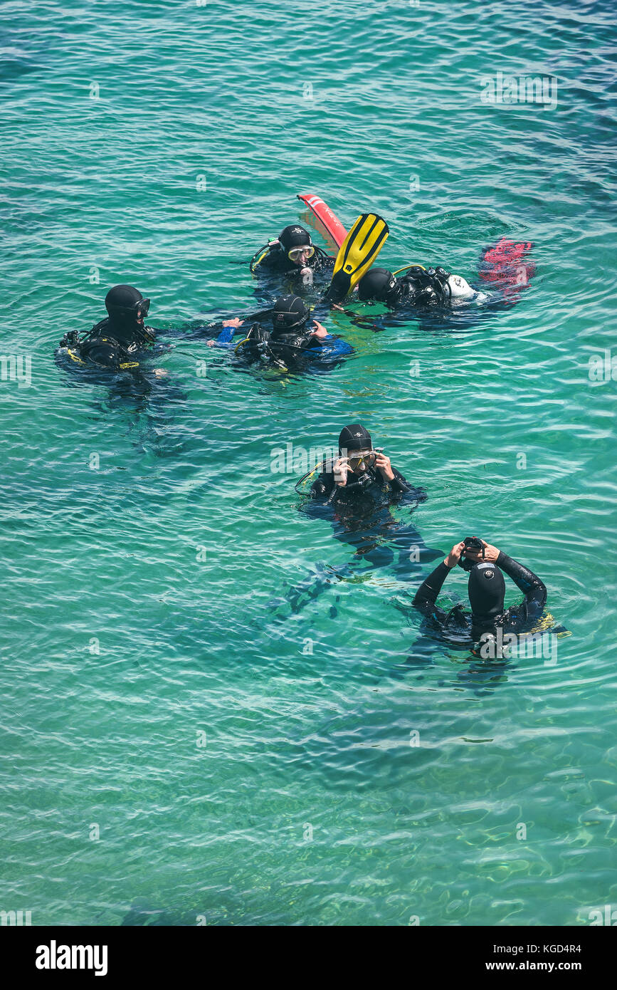 Scuba divers in the sea preparing for a dive Stock Photo - Alamy