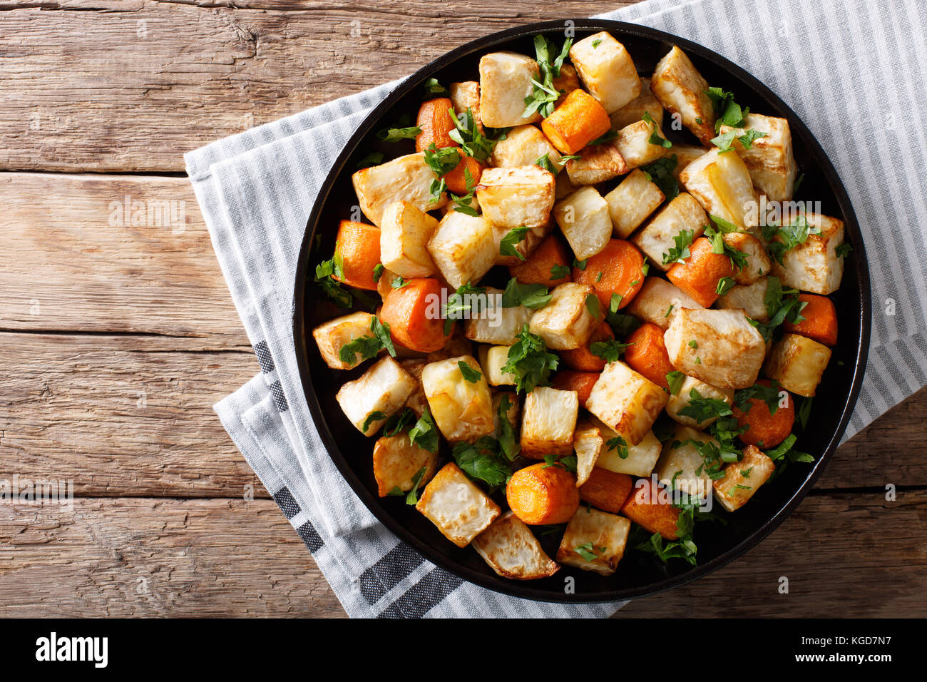 Healthy food: baked celery root and carrots close-up on a plate on a ...