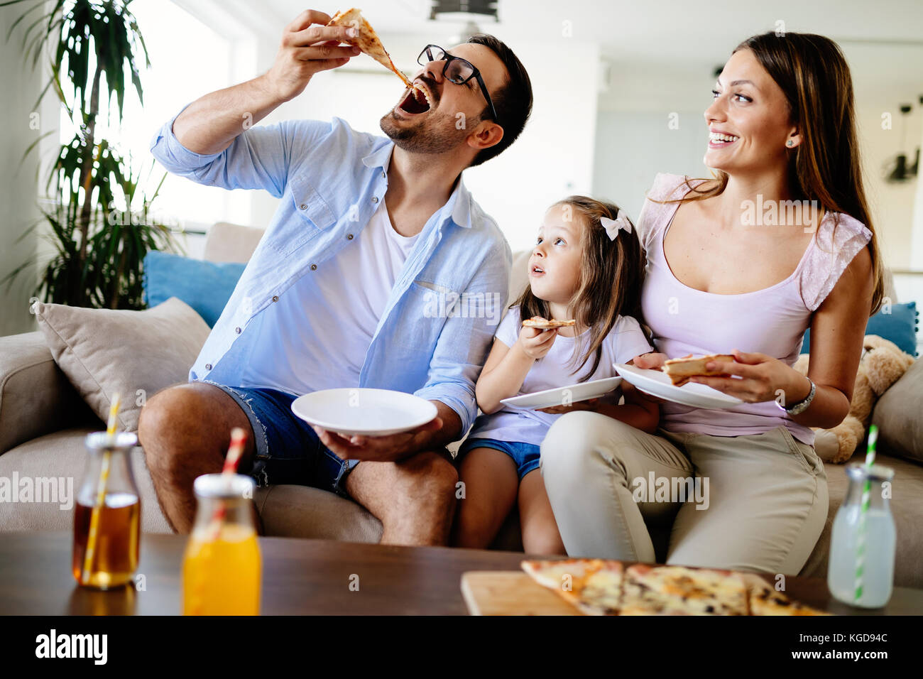 Happy family sharing pizza together at home Stock Photo - Alamy