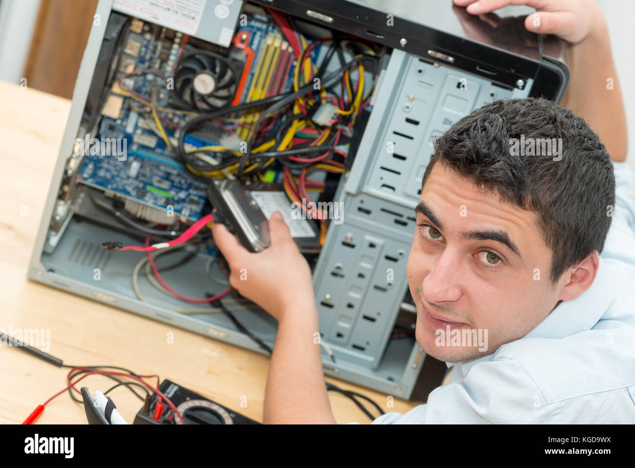 a young technician working on broken computer in his office Stock Photo ...