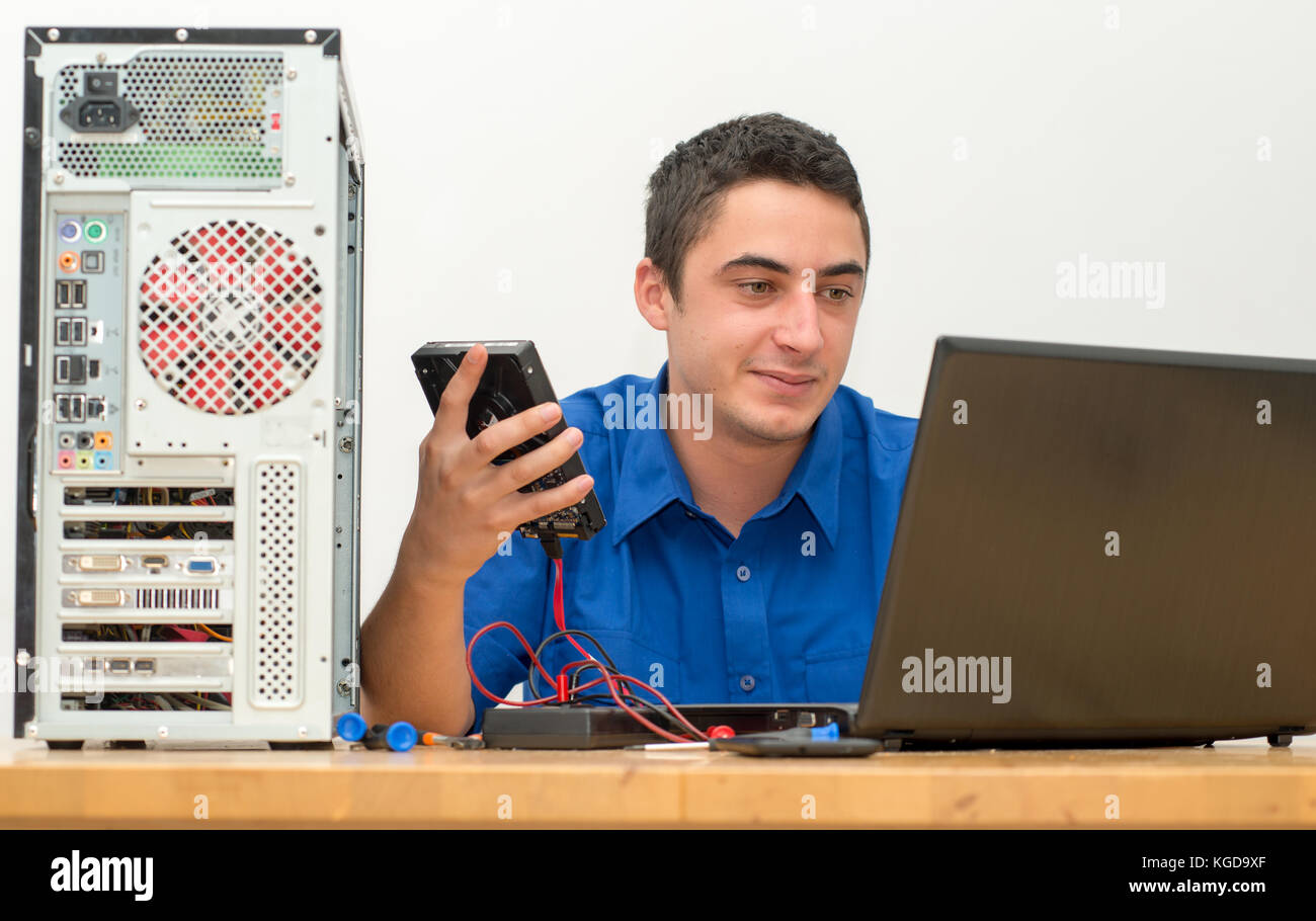 a young technician working on broken computer in his office Stock Photo ...