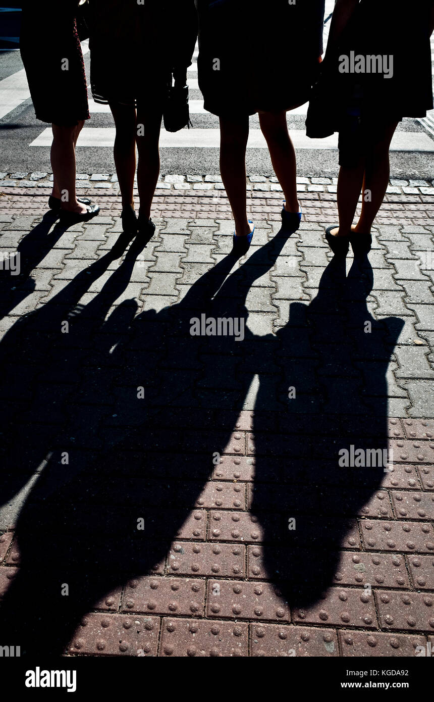 legs of four women standing and long shadows Stock Photo - Alamy