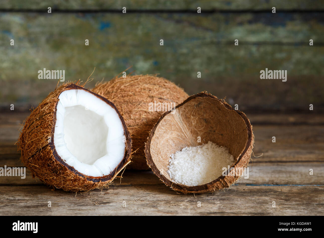 Fresh whole and cut in half coconuts with coconut flakes in shell on ...
