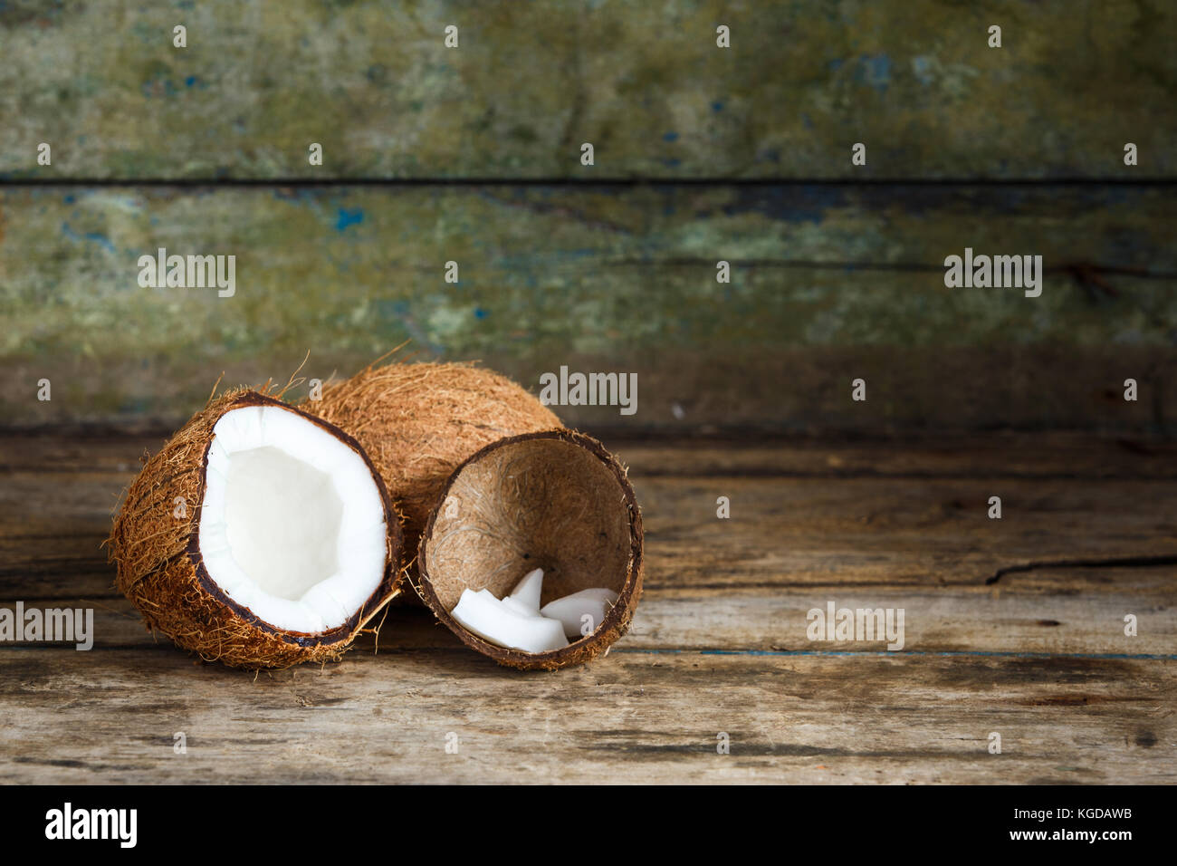 Fresh whole and cut in half coconuts with coconut shreds in shell on ...