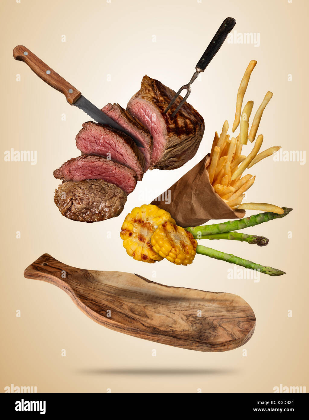 Flying beef steaks with grilled vegetable and french fries served on ...