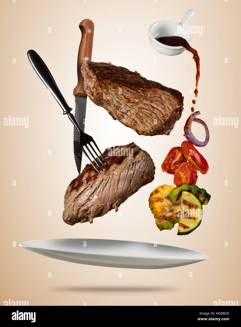 Flying beef steaks with grilled vegetable served on plate. Concept of ...