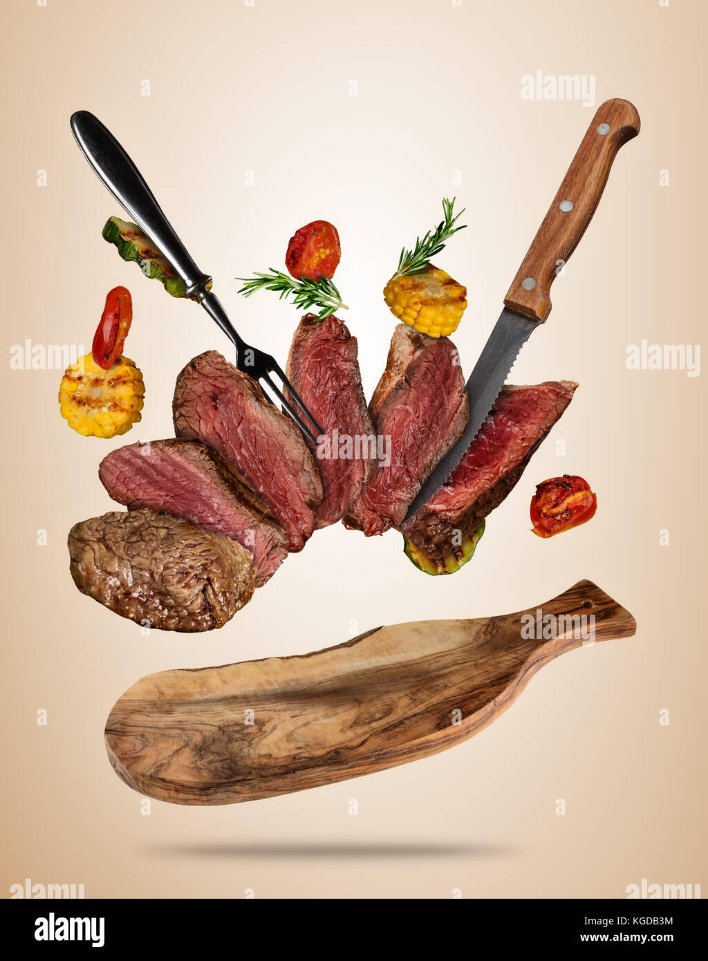Flying beef steaks with grilled vegetable served on wooden cutting ...