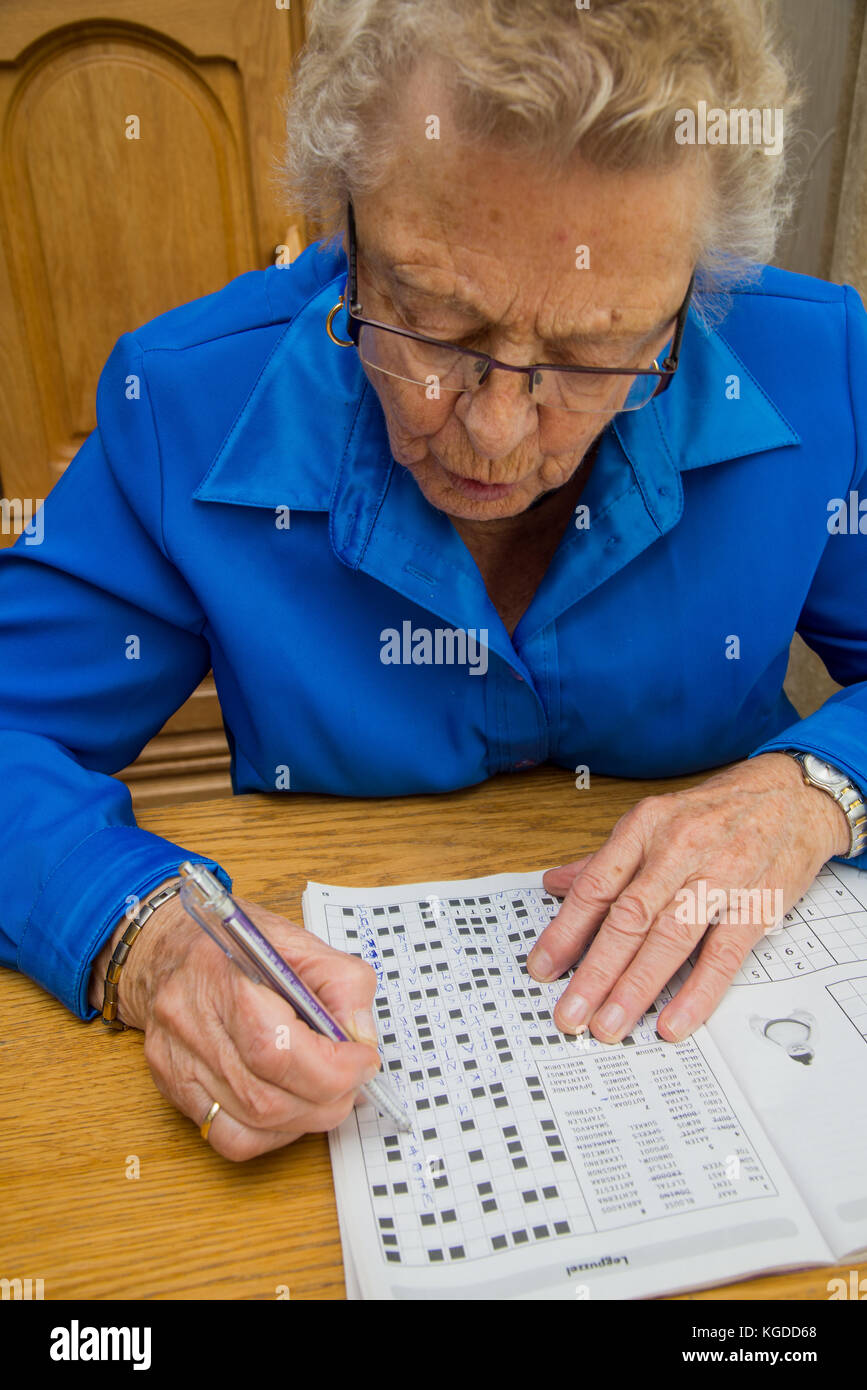 old woman puzzles at table Stock Photo - Alamy