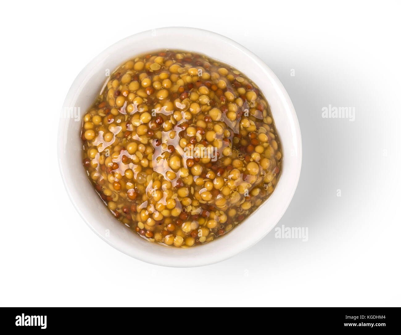 Typical french dijon rough mustard in round dish from above on white ...