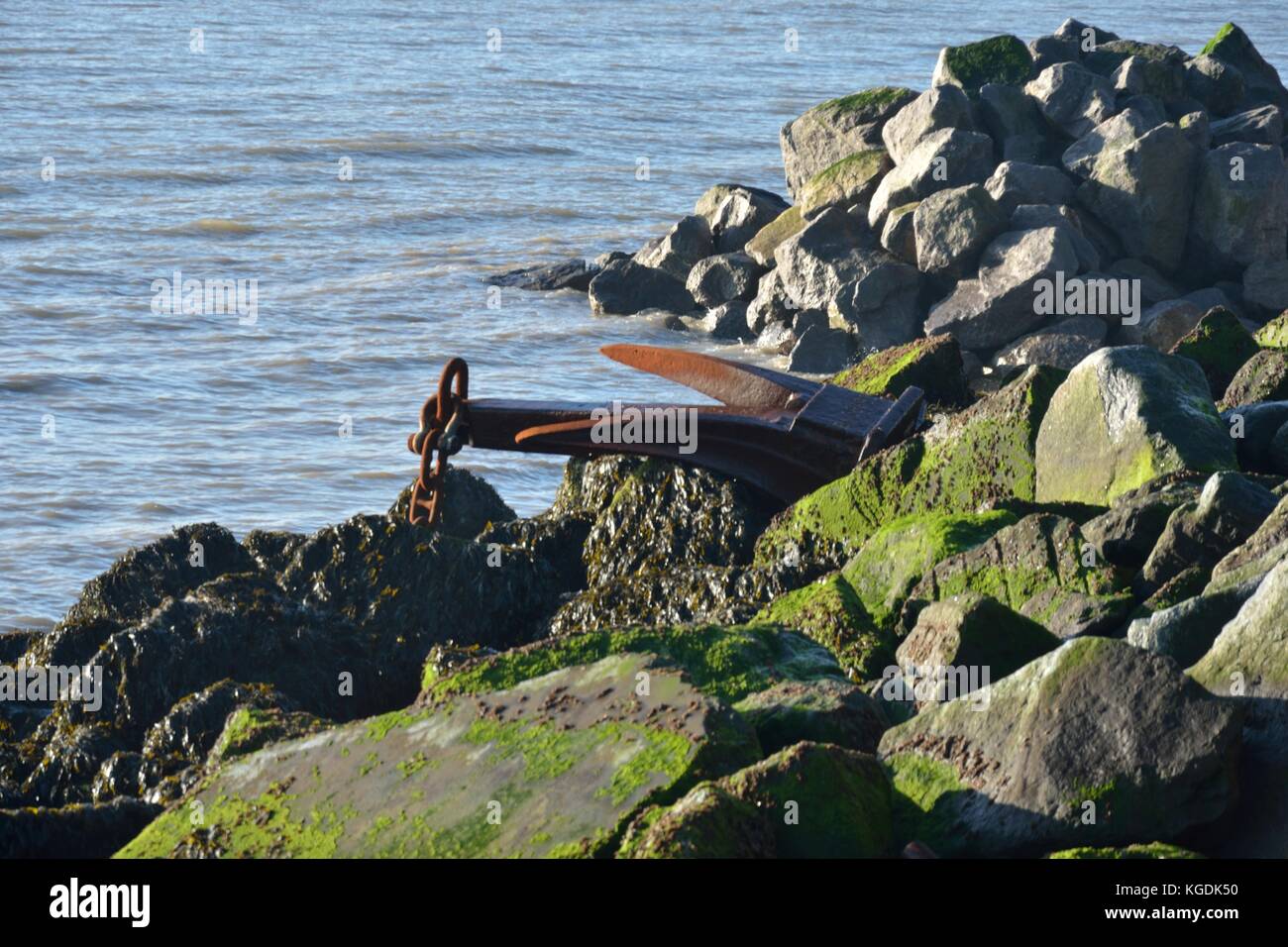 rusty anchor on rocks Stock Photo - Alamy
