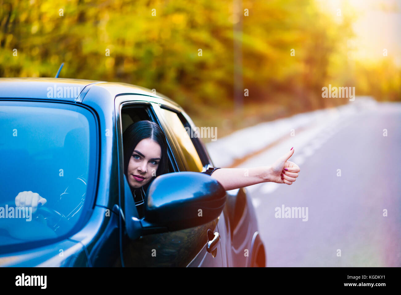 A beautiful brunette driver shows the ok sign on the car window Stock ...