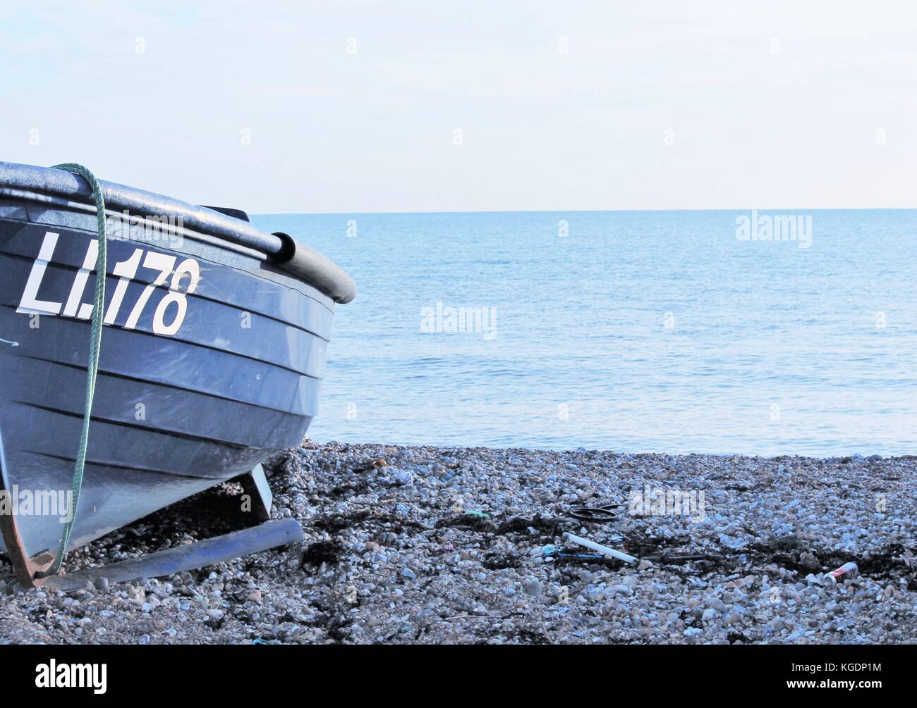 Fishing boat on pebble beach shore Stock Photo - Alamy