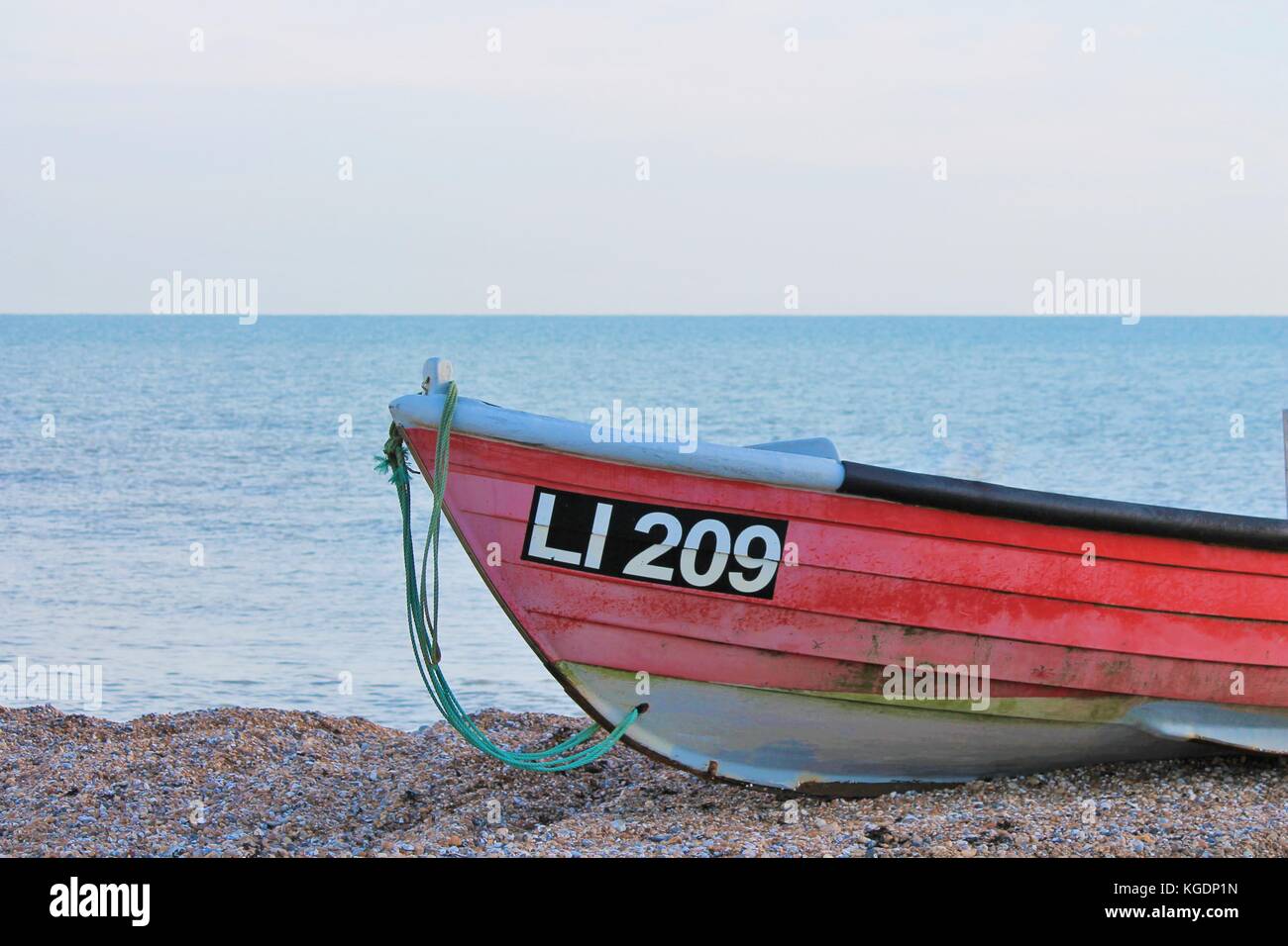Fishing boat on pebble beach shore Stock Photo - Alamy