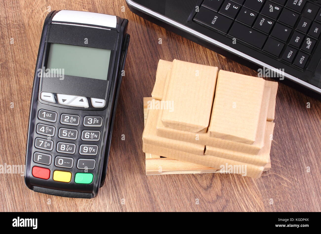 Payment terminal, laptop and small wrapped boxes on pallet, cashless ...