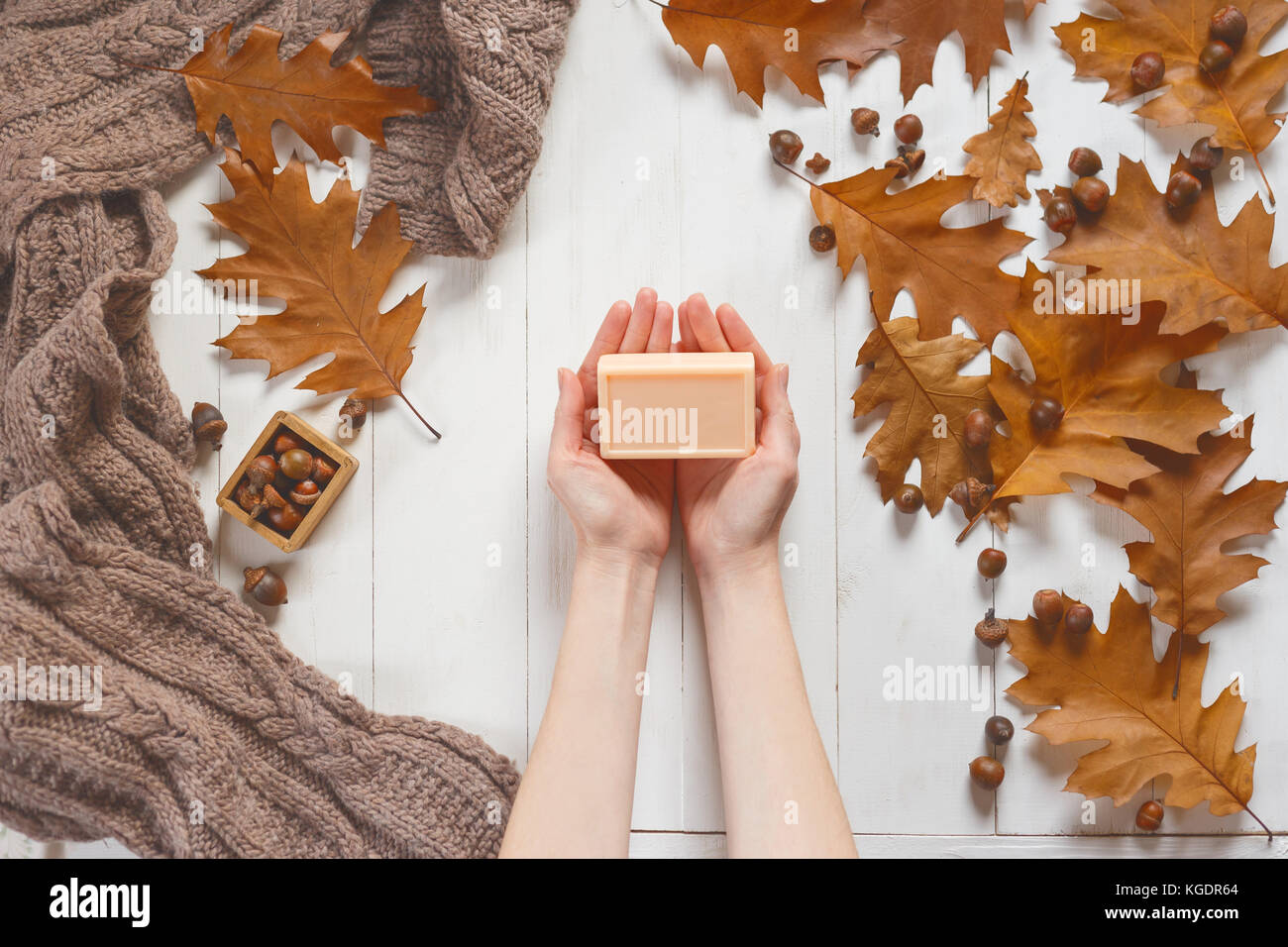 Piece of soap flesh-colored in female hands in a composition with a ...