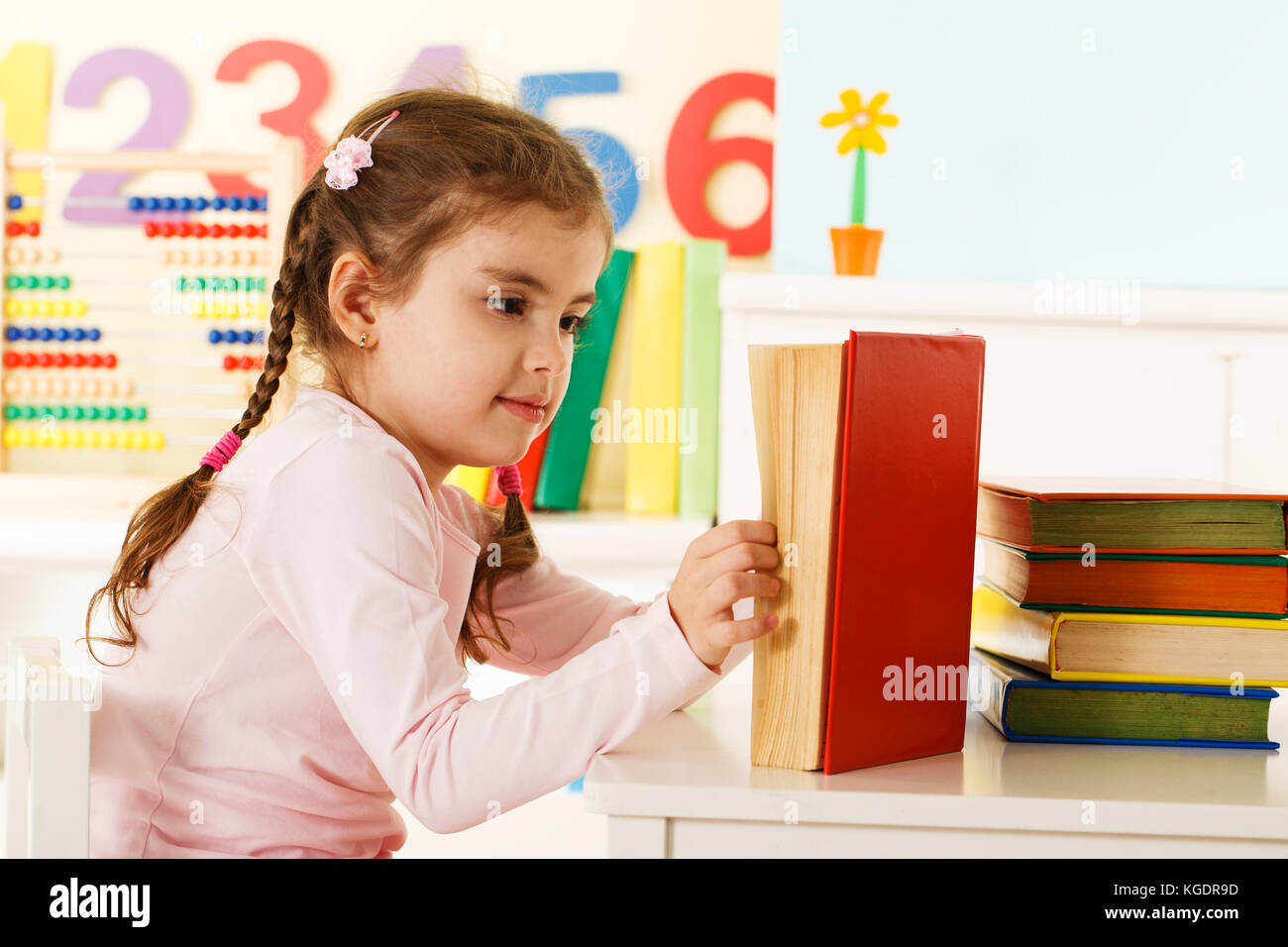 Preschool girl with a books Stock Photo - Alamy
