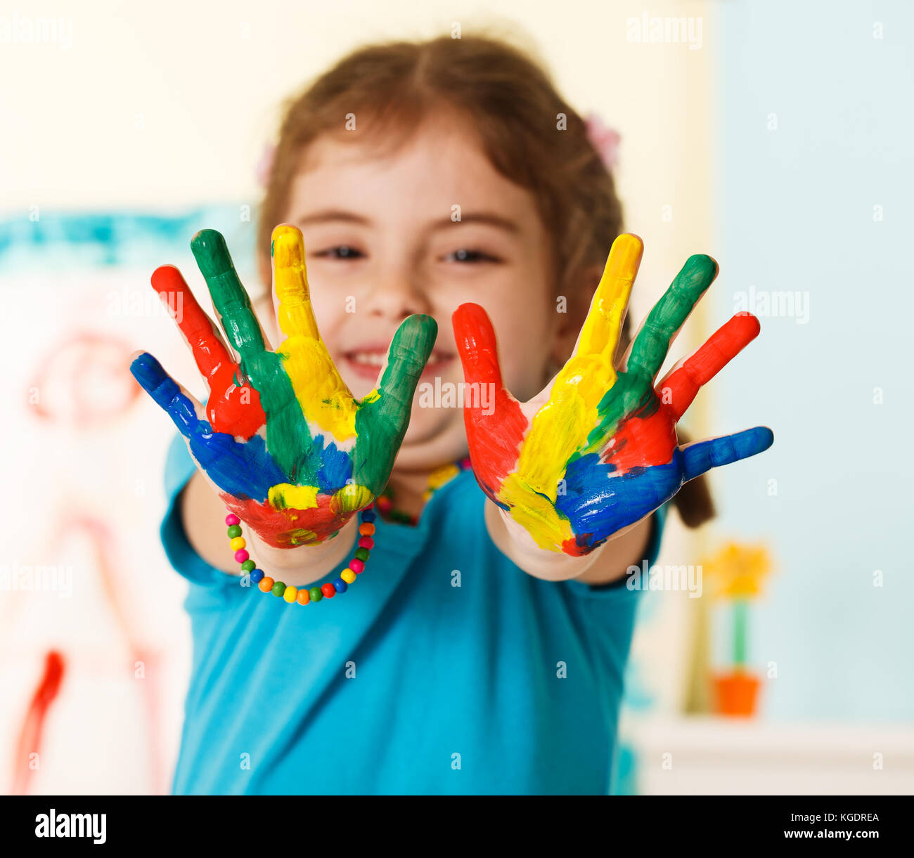 Five year old girl with hands painted in colorful paints ready for hand ...
