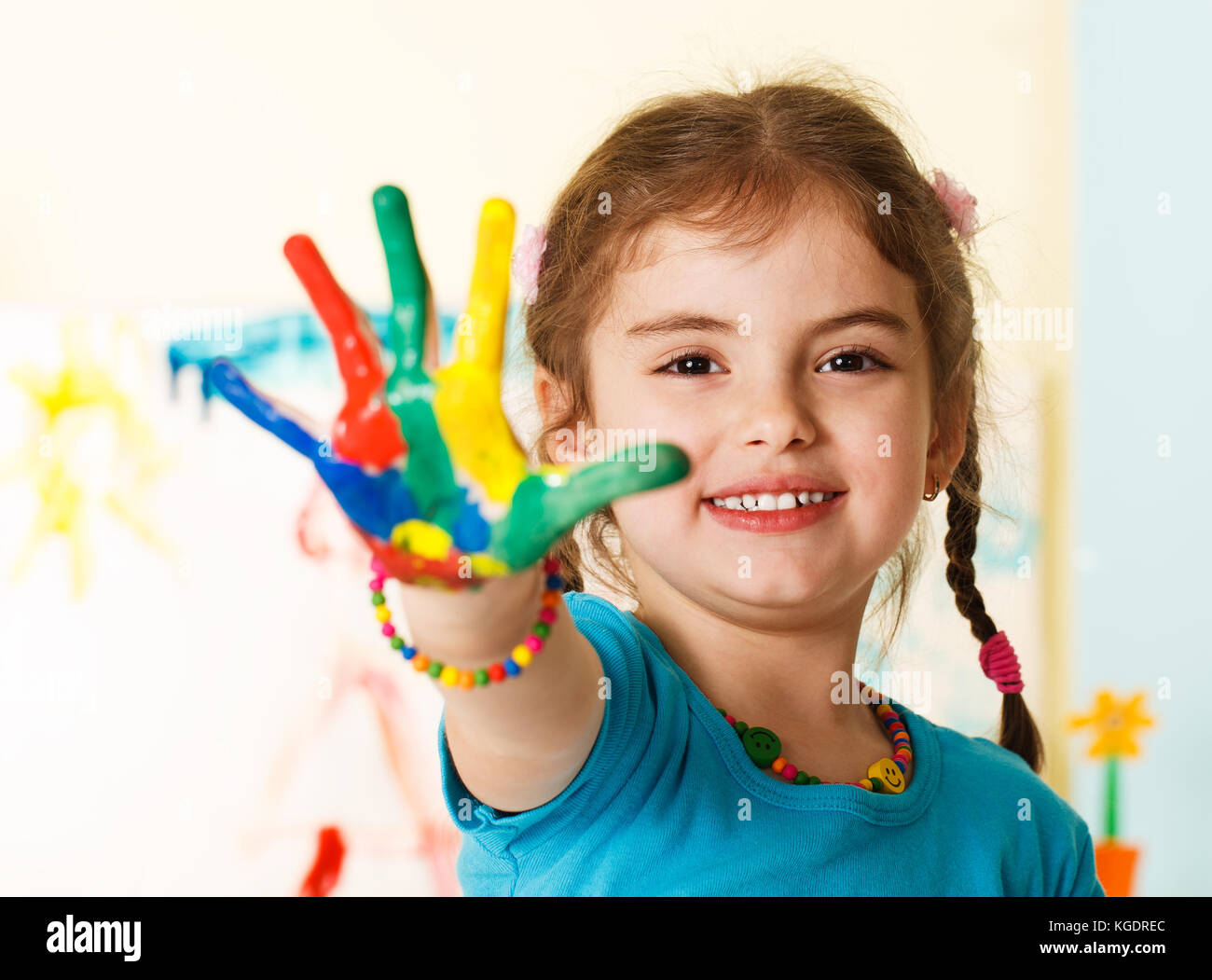 Five year old girl with hands painted in colorful paints ready for hand ...