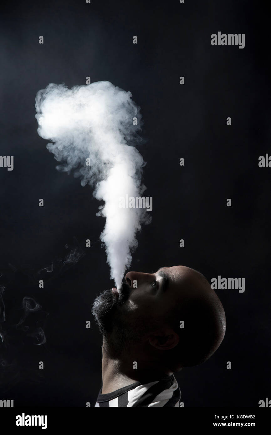 Bald man vaping. Studio shot. Black background Stock Photo - Alamy